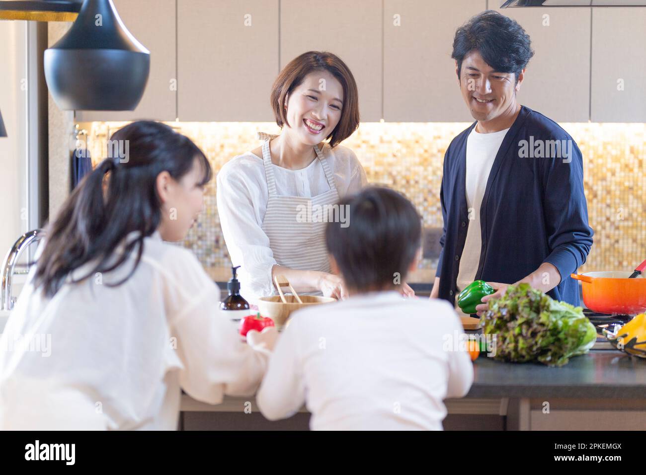 A couple standing in the kitchen and a brother and sister talking Stock ...