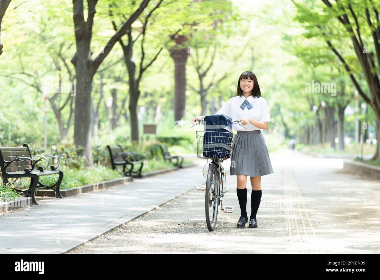 High school girl pushing a bicycle Stock Photo - Alamy