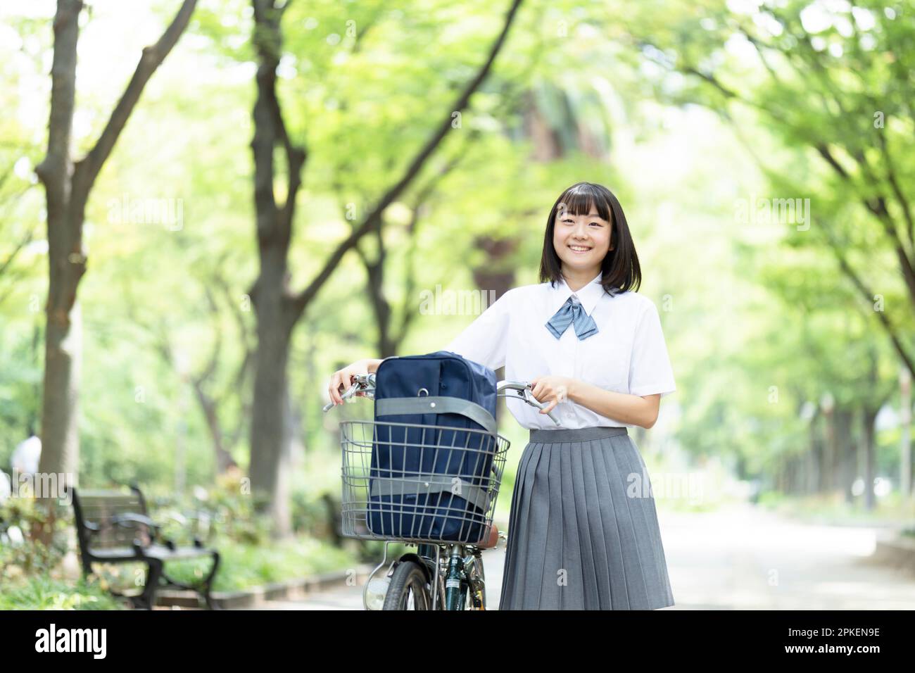 High school girl pushing a bicycle Stock Photo - Alamy
