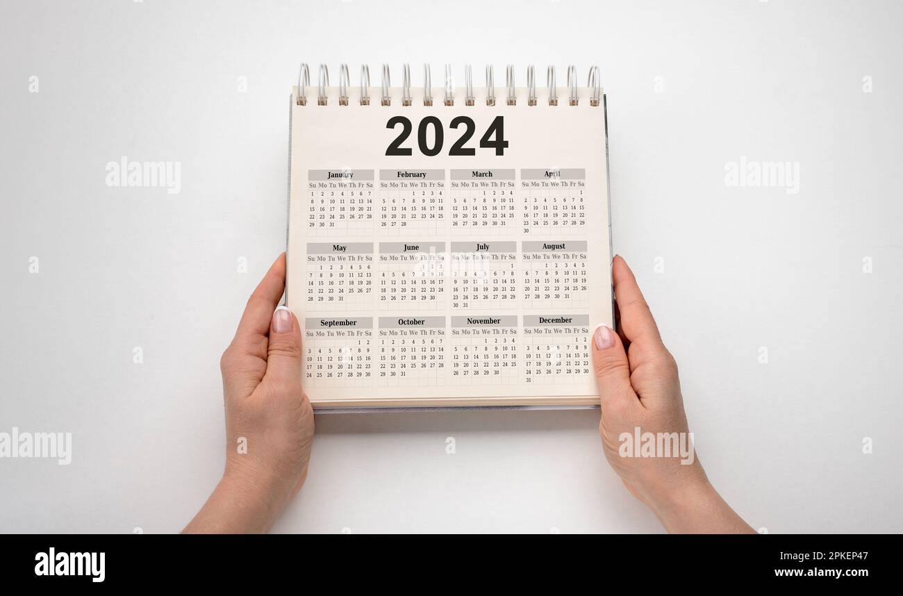 Calendar Year 2024 schedule. hands hold 2024 desk calender notepad on ...