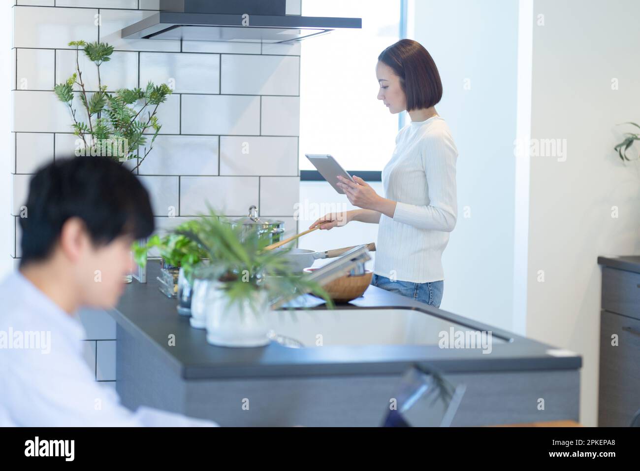 Woman cooking man sitting table hi-res stock photography and images - Alamy