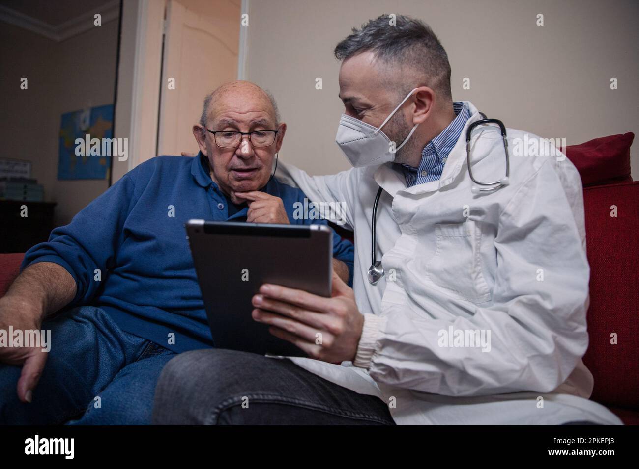 A general practitioner visits his elderly patient in his home Stock ...