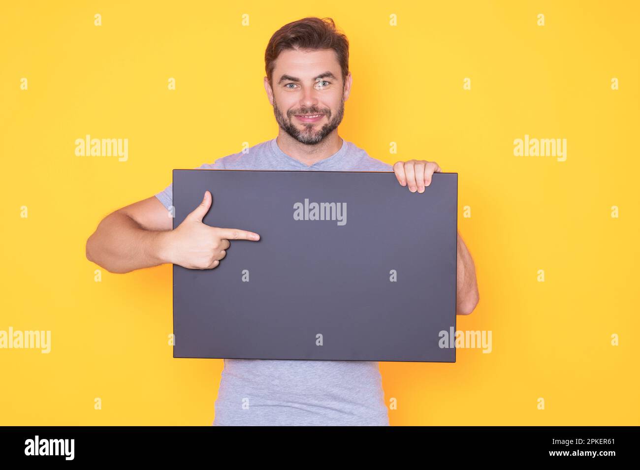 Man in studio showing promo blank board pointing finger on sign board ...