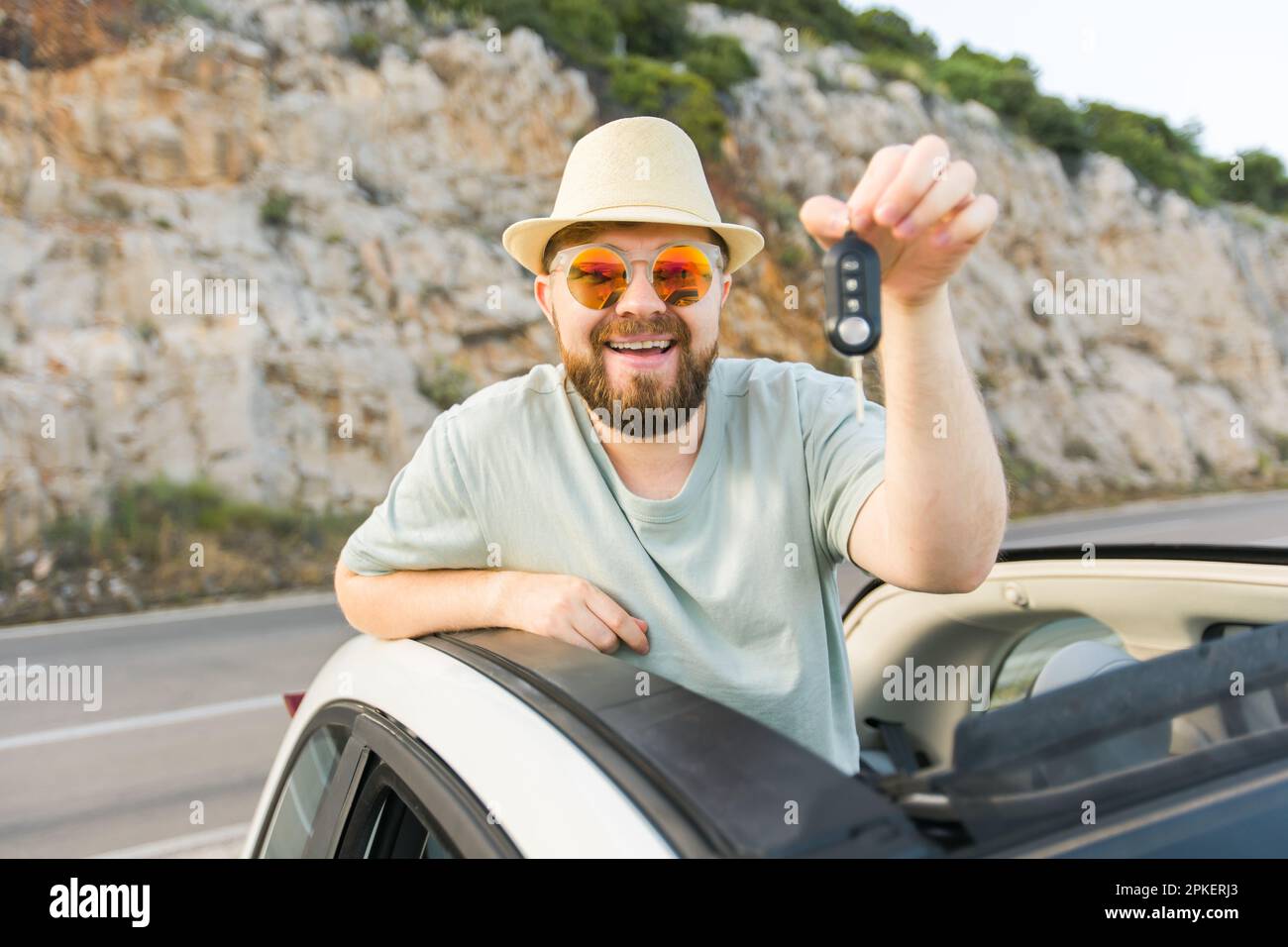 Car driver man smiling showing new car keys and car. Bearded guy ...