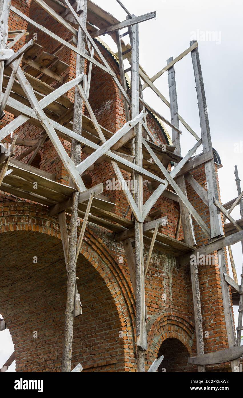 construction of a bell tower and a church. Brick wall. Wooden ...