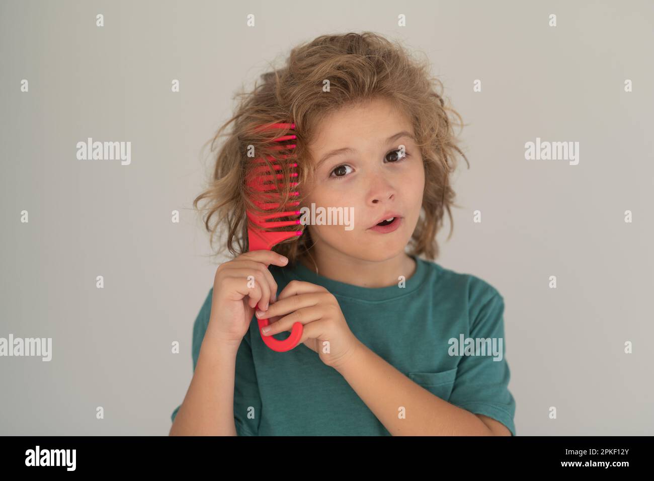 Comb and hair brush concept. Cute funny child with curly blonde hair ...
