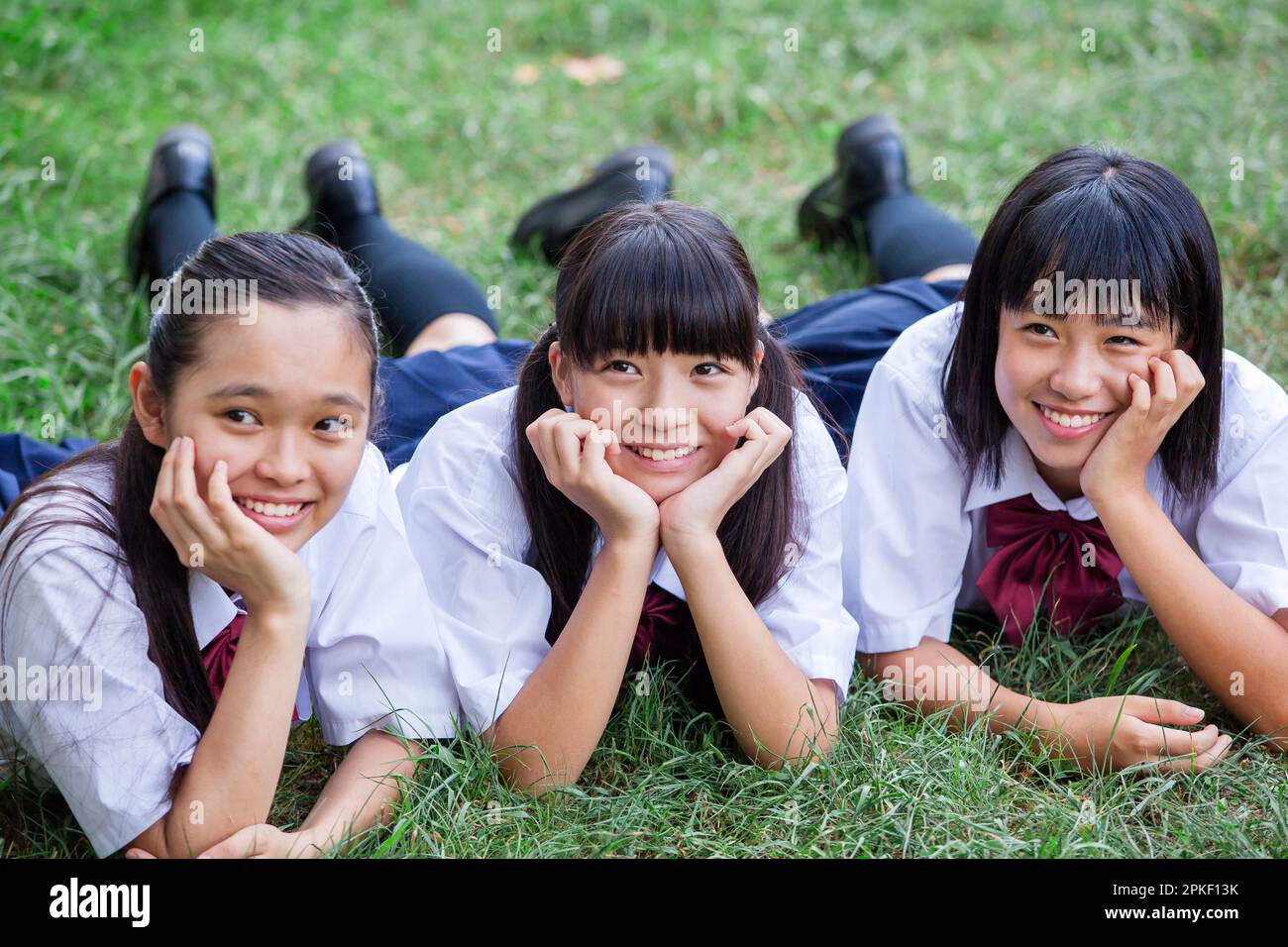 Junior high school student lying on his back on the field with ...