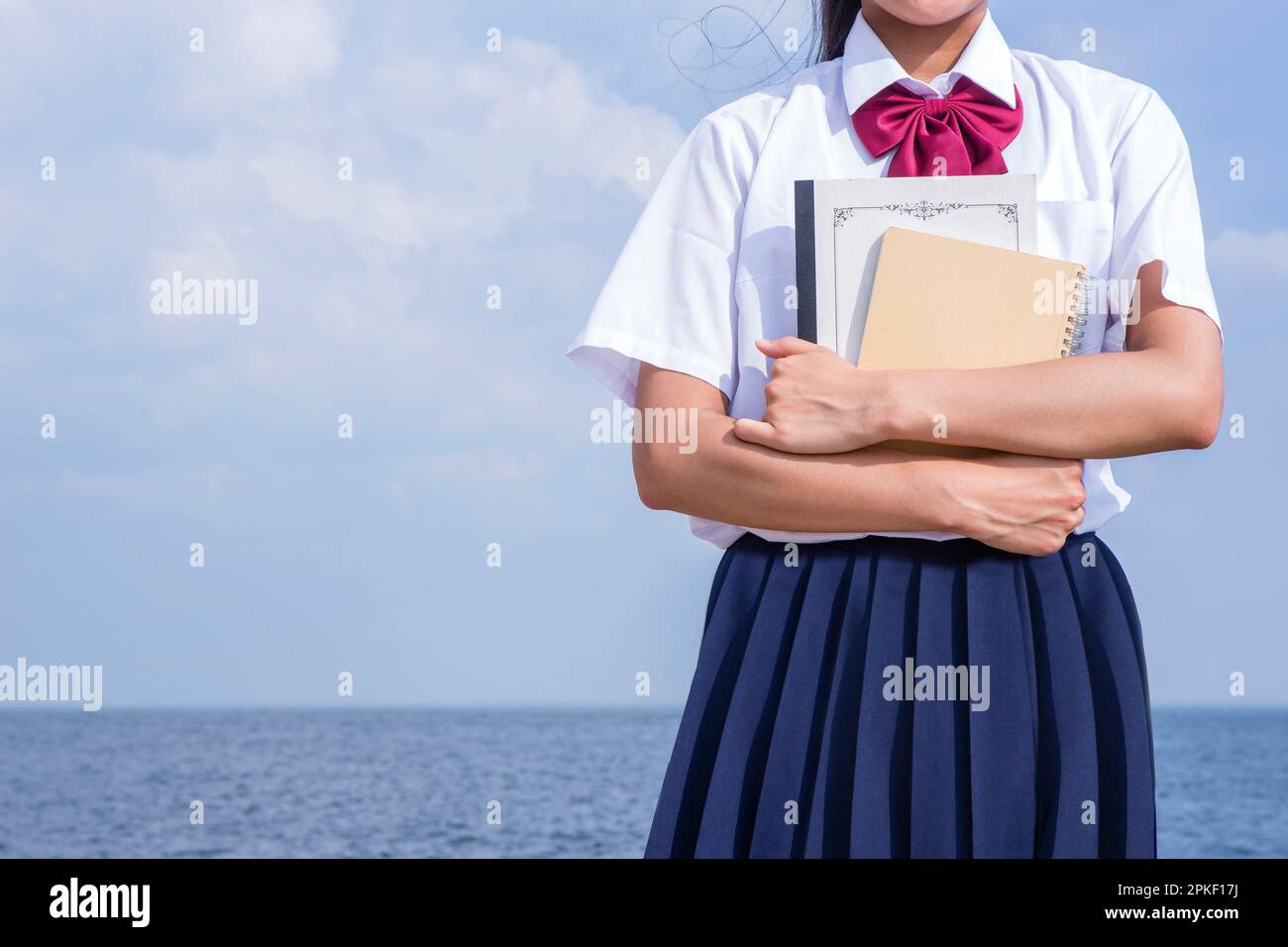 Junior high school students holding notebooks on the beach Stock Photo ...