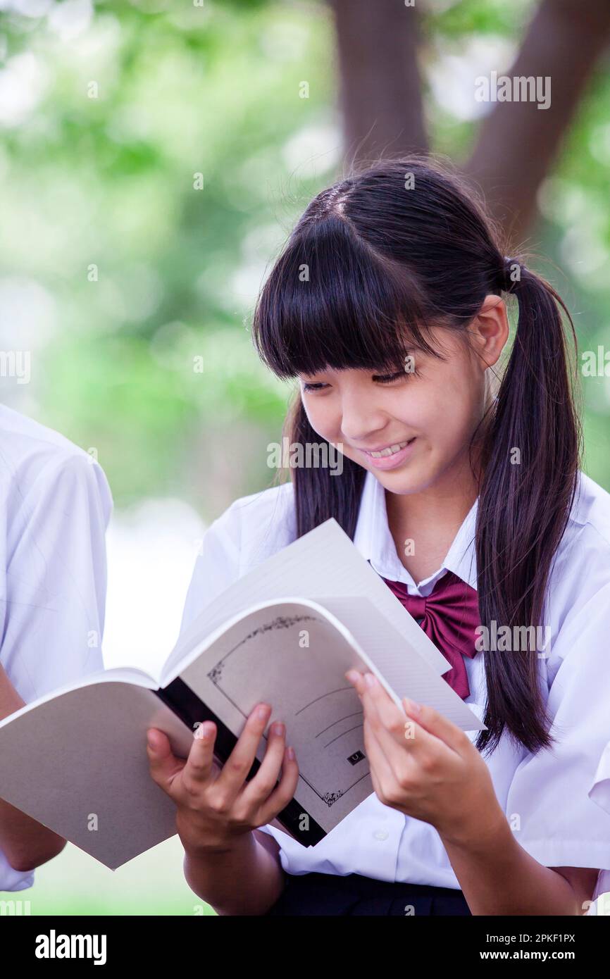 Junior high school students reading notebooks outdoors Stock Photo - Alamy