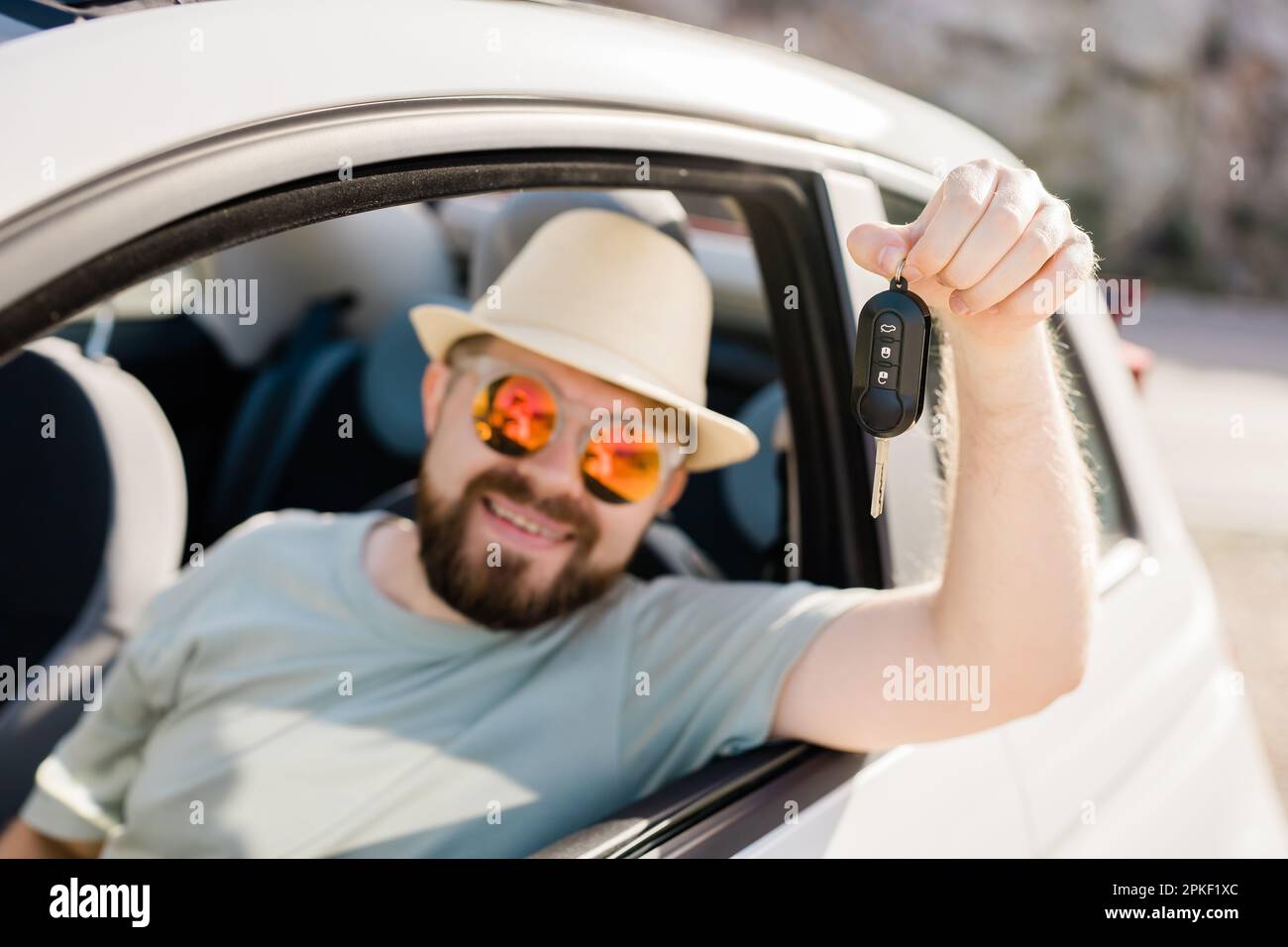 Car driver man smiling showing new car keys and car. Bearded guy ...