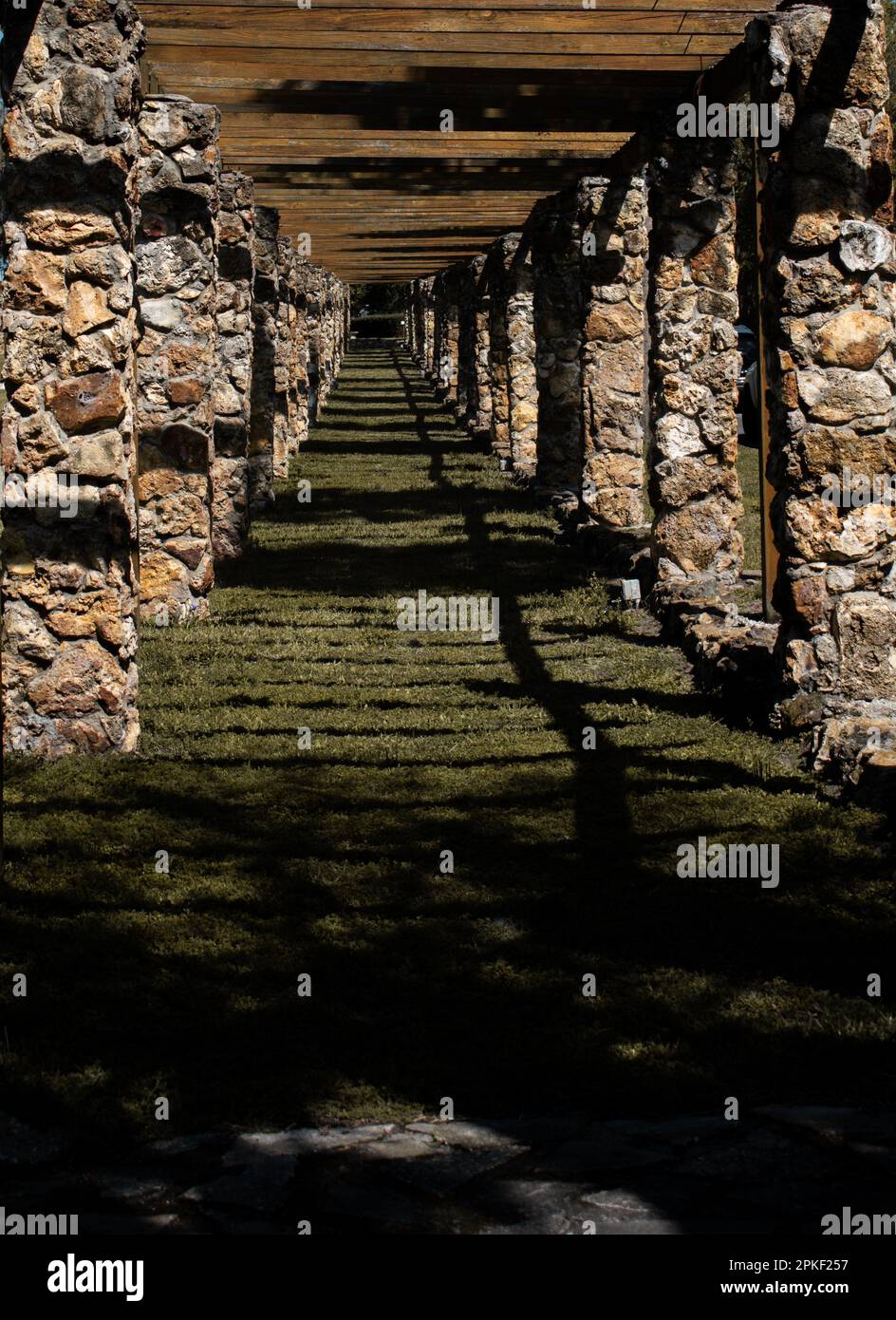 A row of stone archways forming a pathway in a forested area Stock ...