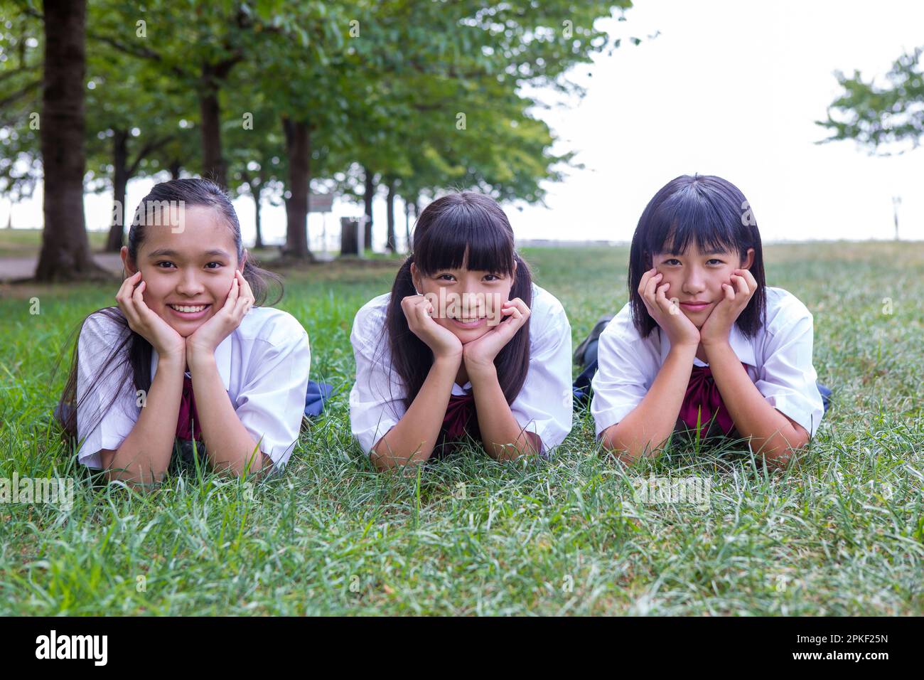 A junior high school student lying on his cheek on the grass Stock ...