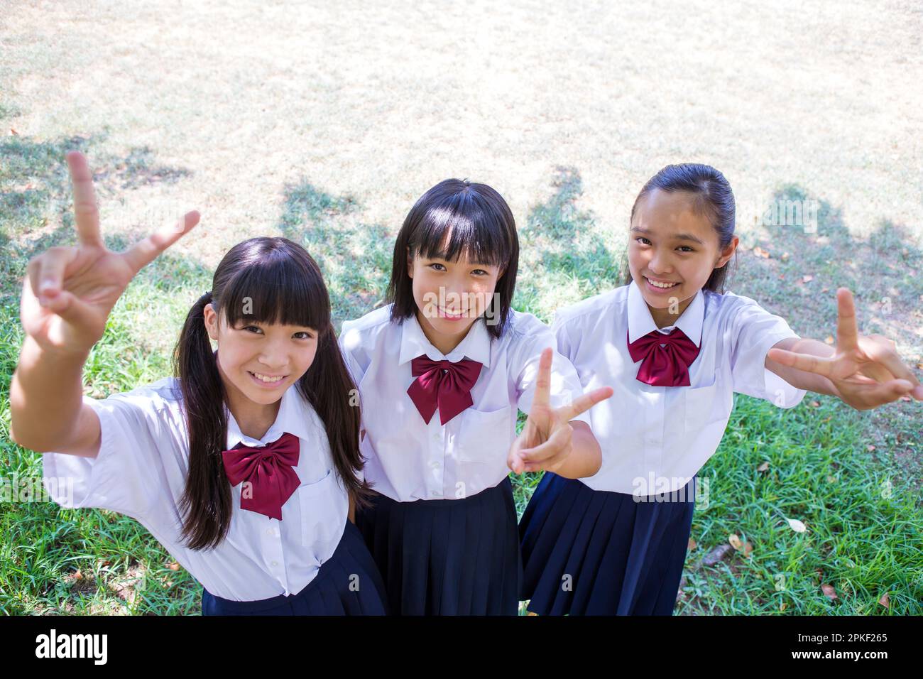 Junior high school students making a peace gesture toward the top Stock ...