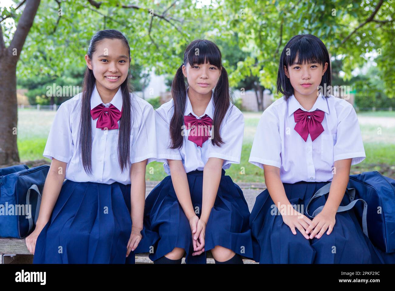 Junior high school students sitting on a bench Stock Photo - Alamy