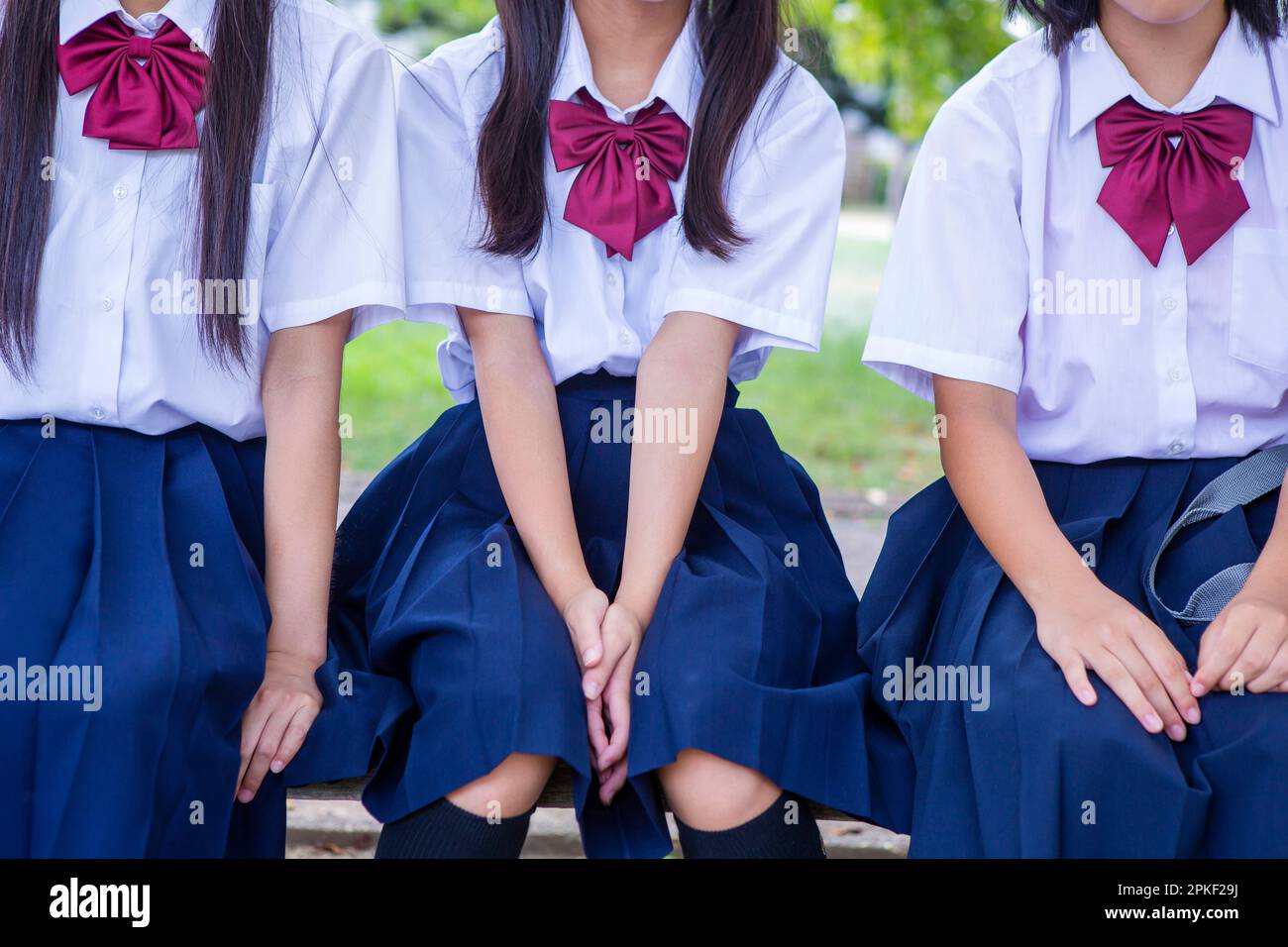Junior high school students sitting on a bench Stock Photo - Alamy