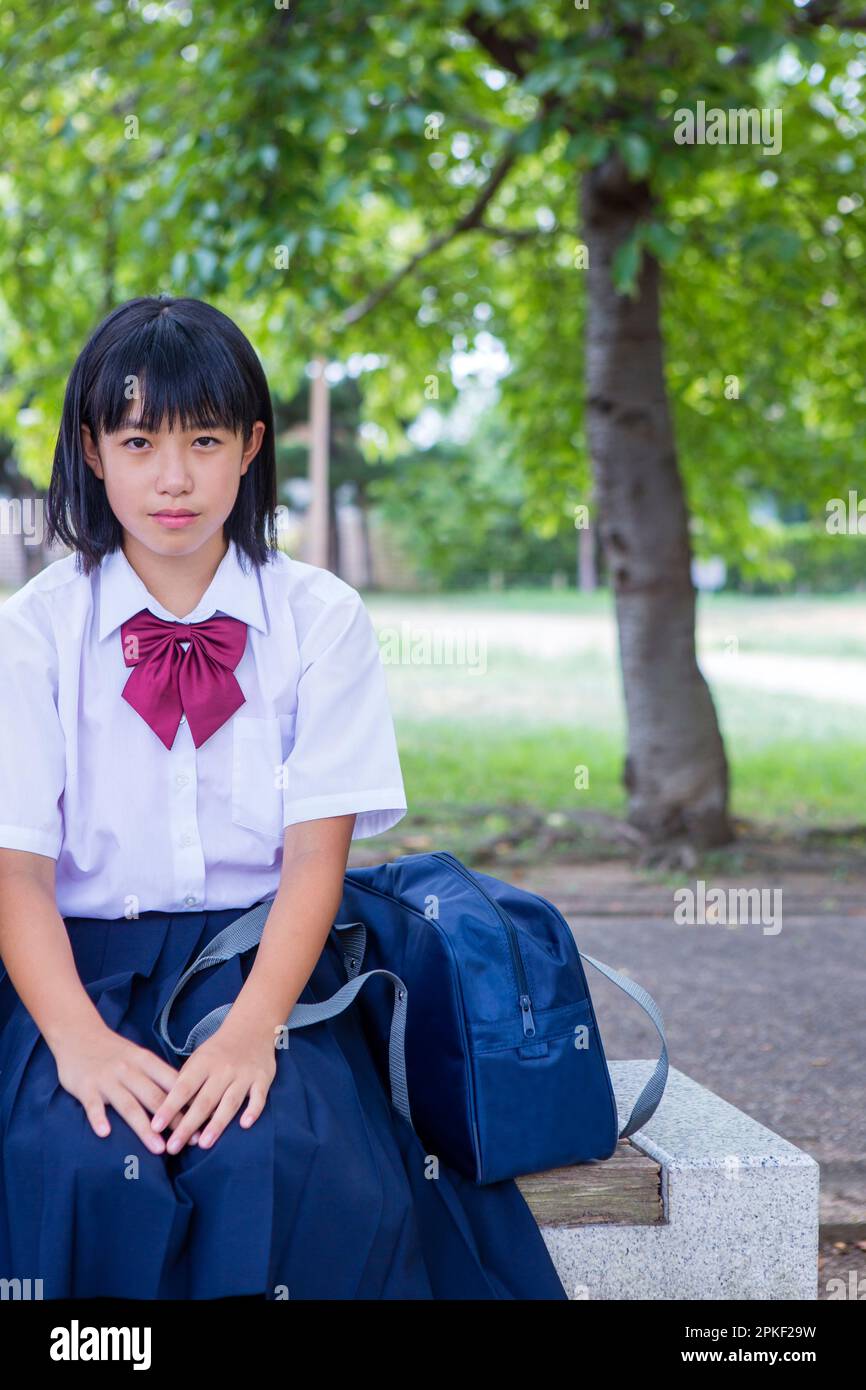 Junior high school students sitting on a bench Stock Photo - Alamy