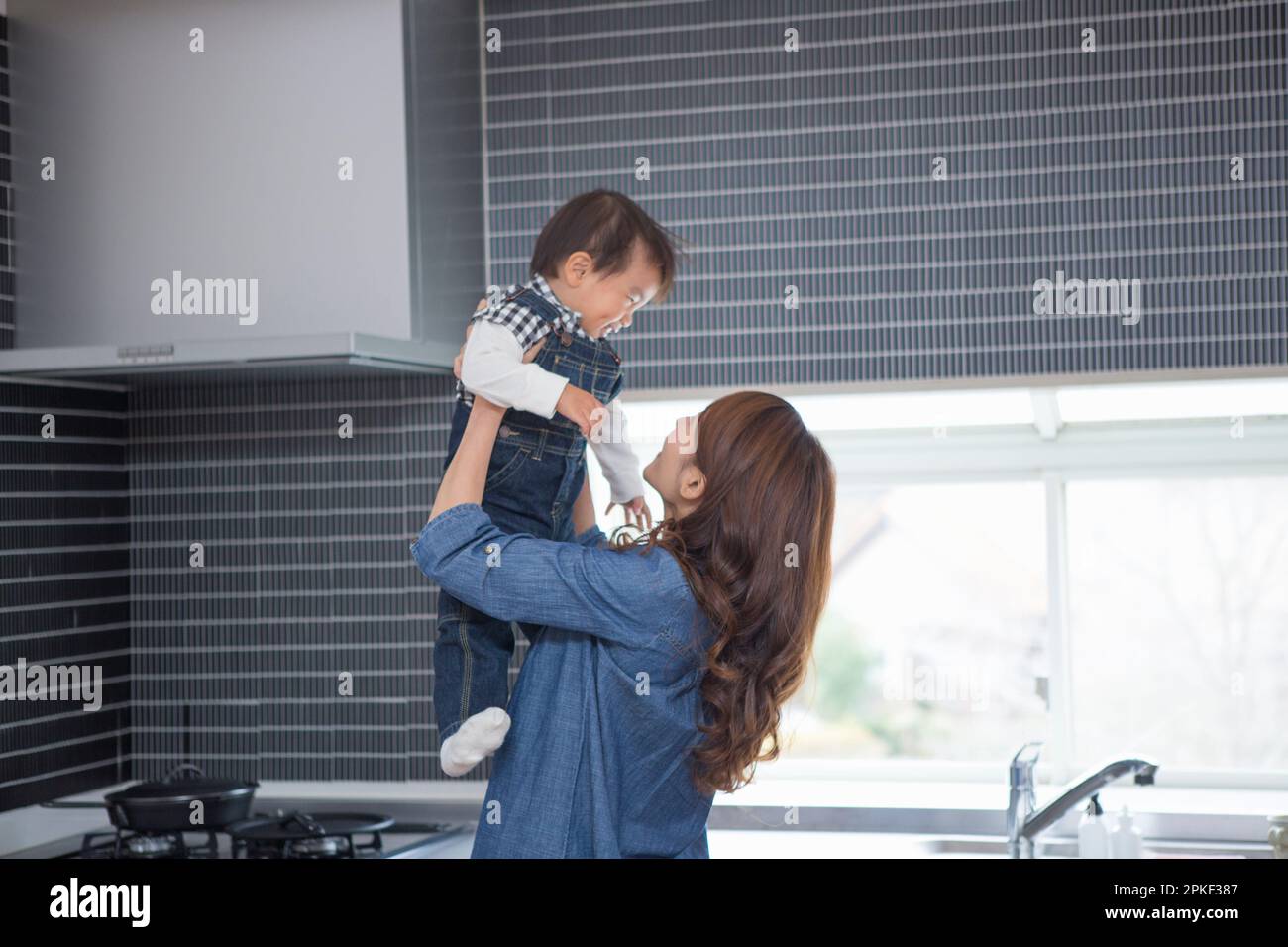 Mother lifting child high Stock Photo - Alamy
