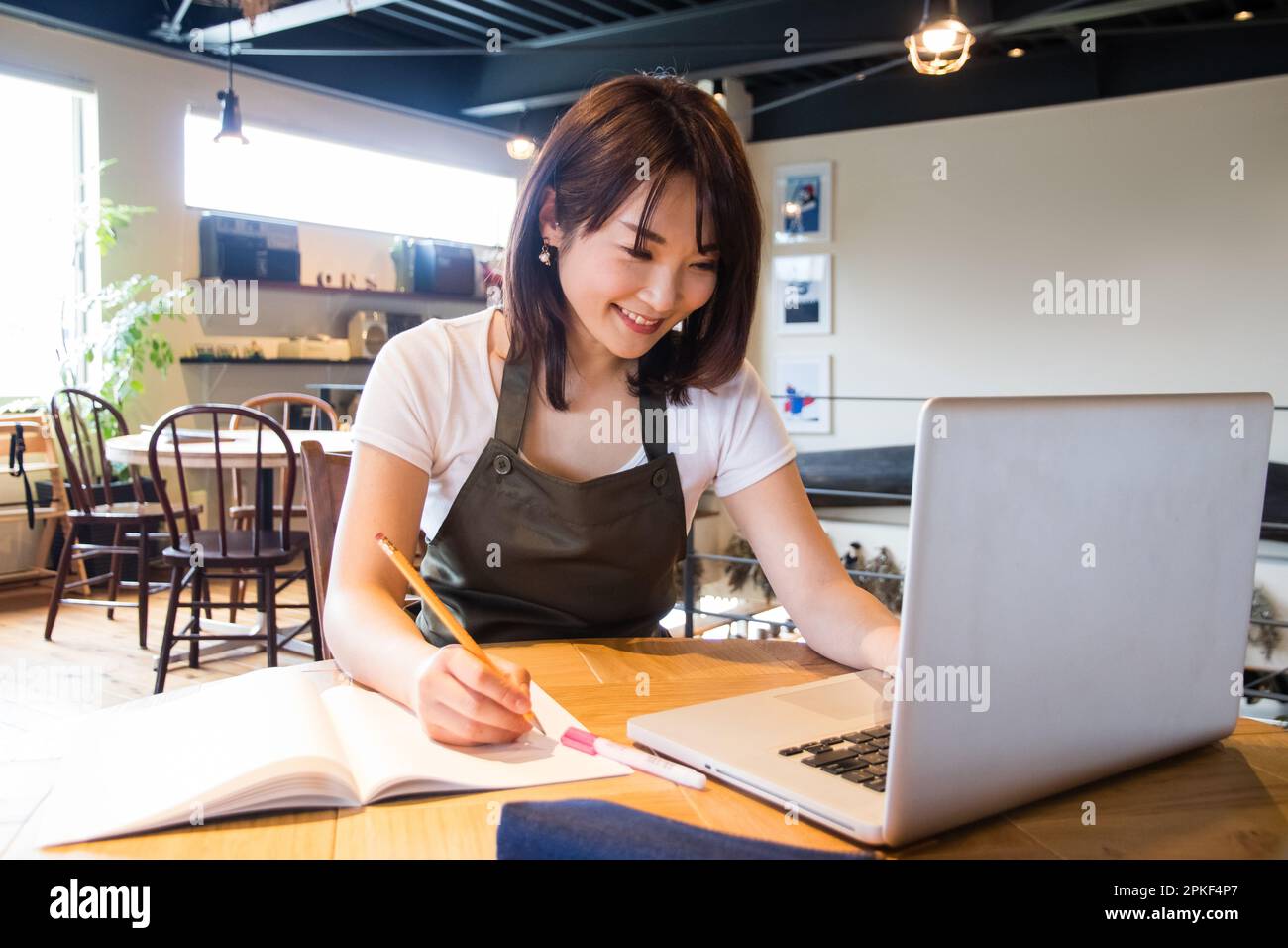 Cafe worker using a computer Stock Photo - Alamy