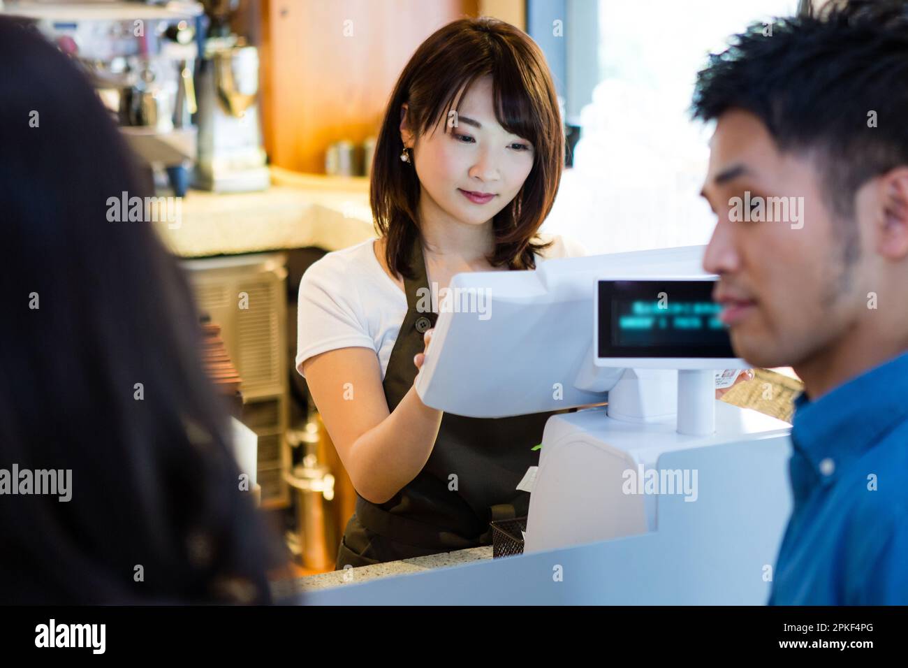 A café worker working the cash register Stock Photo - Alamy