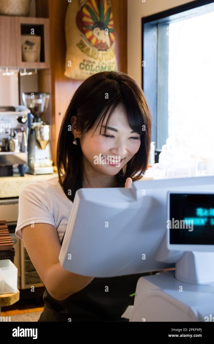 A worker at a café working the cash register Stock Photo - Alamy