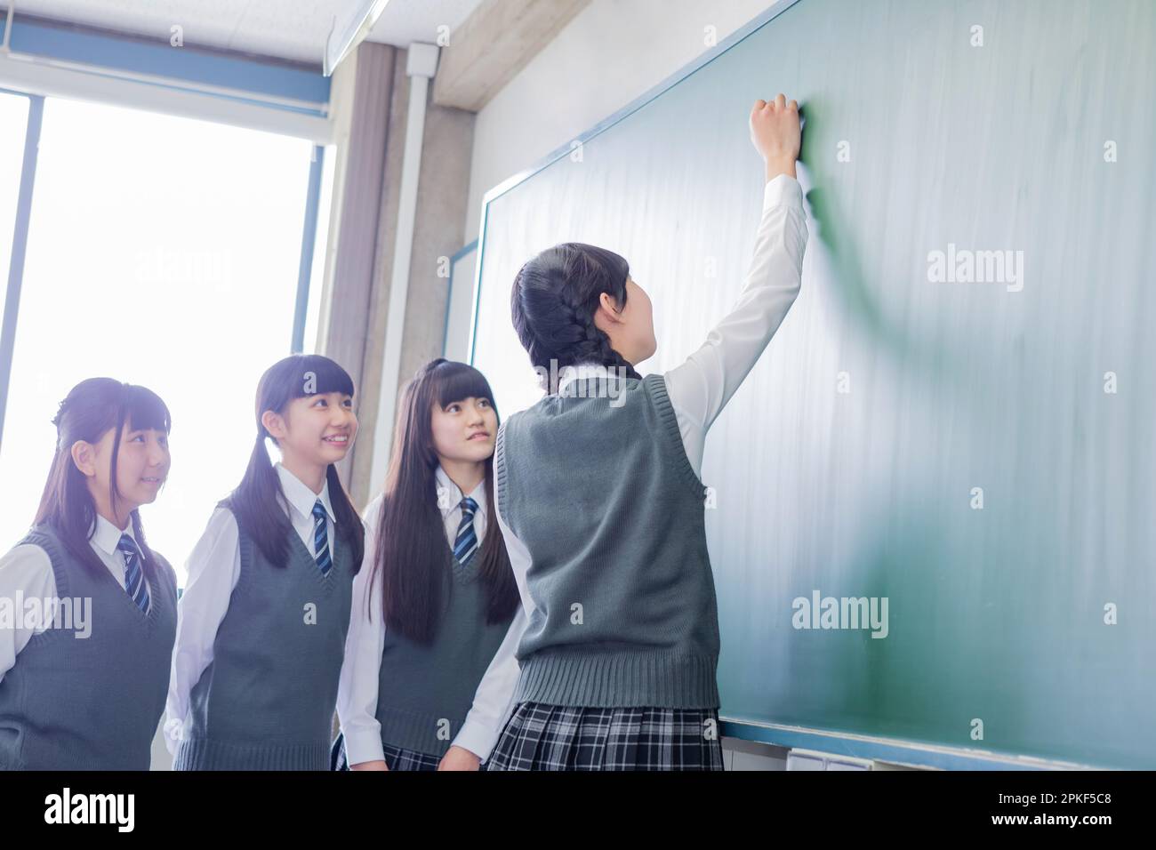 Junior high school girl writing with chalk on the blackboard Stock ...