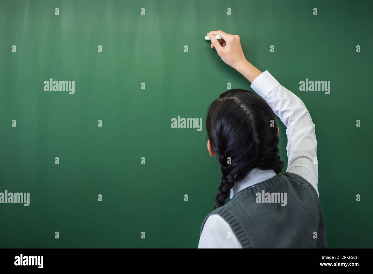 Junior high school girls writing with chalk on the blackboard Stock ...