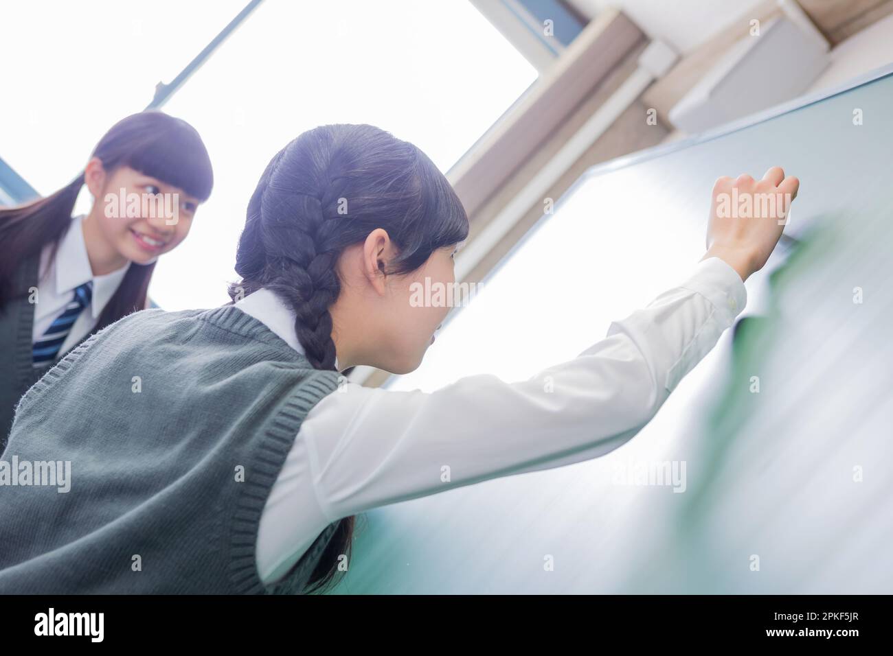 Junior high school girls writing with chalk on the blackboard Stock ...