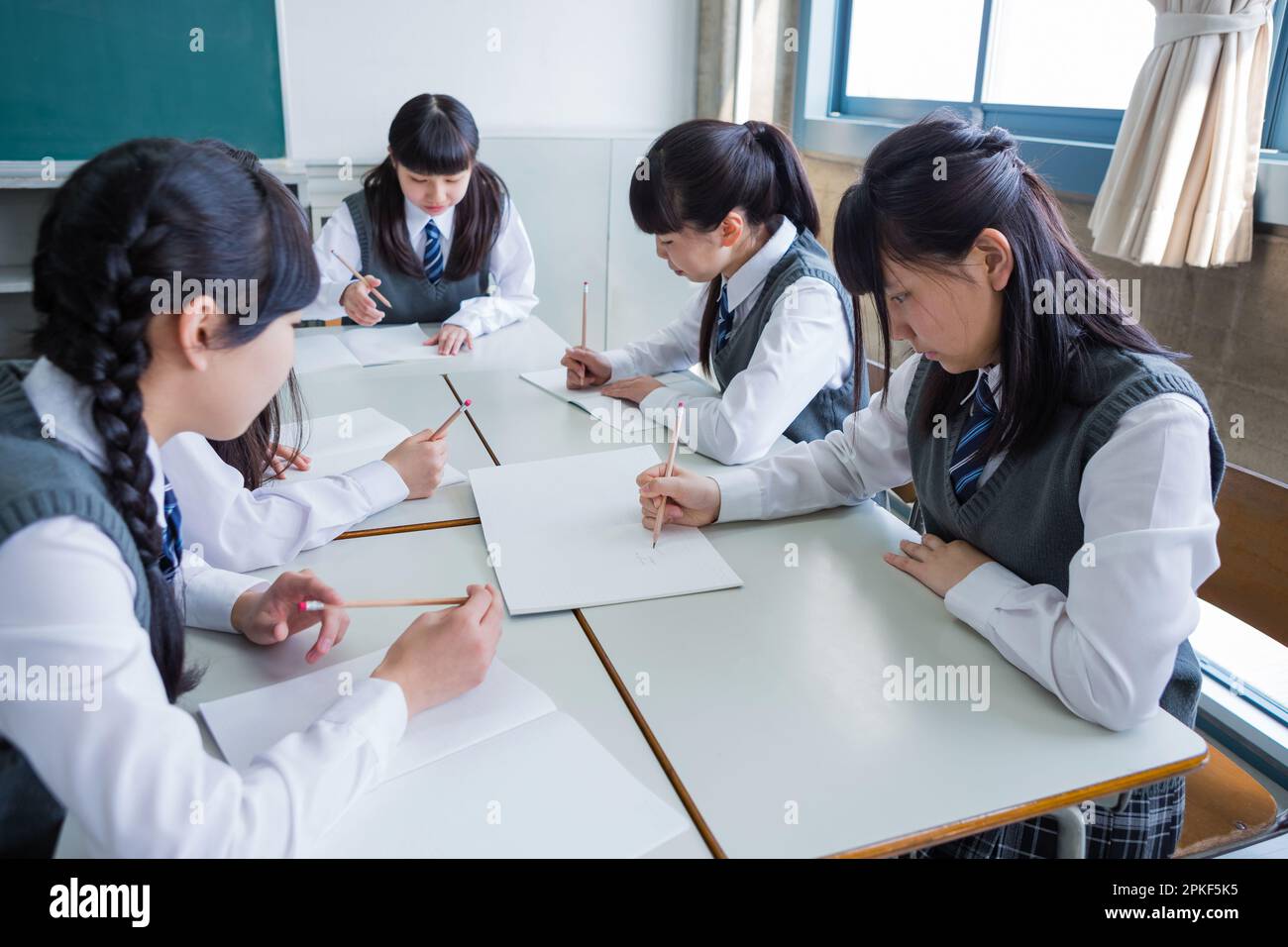 Junior high school girls doing group work Stock Photo - Alamy