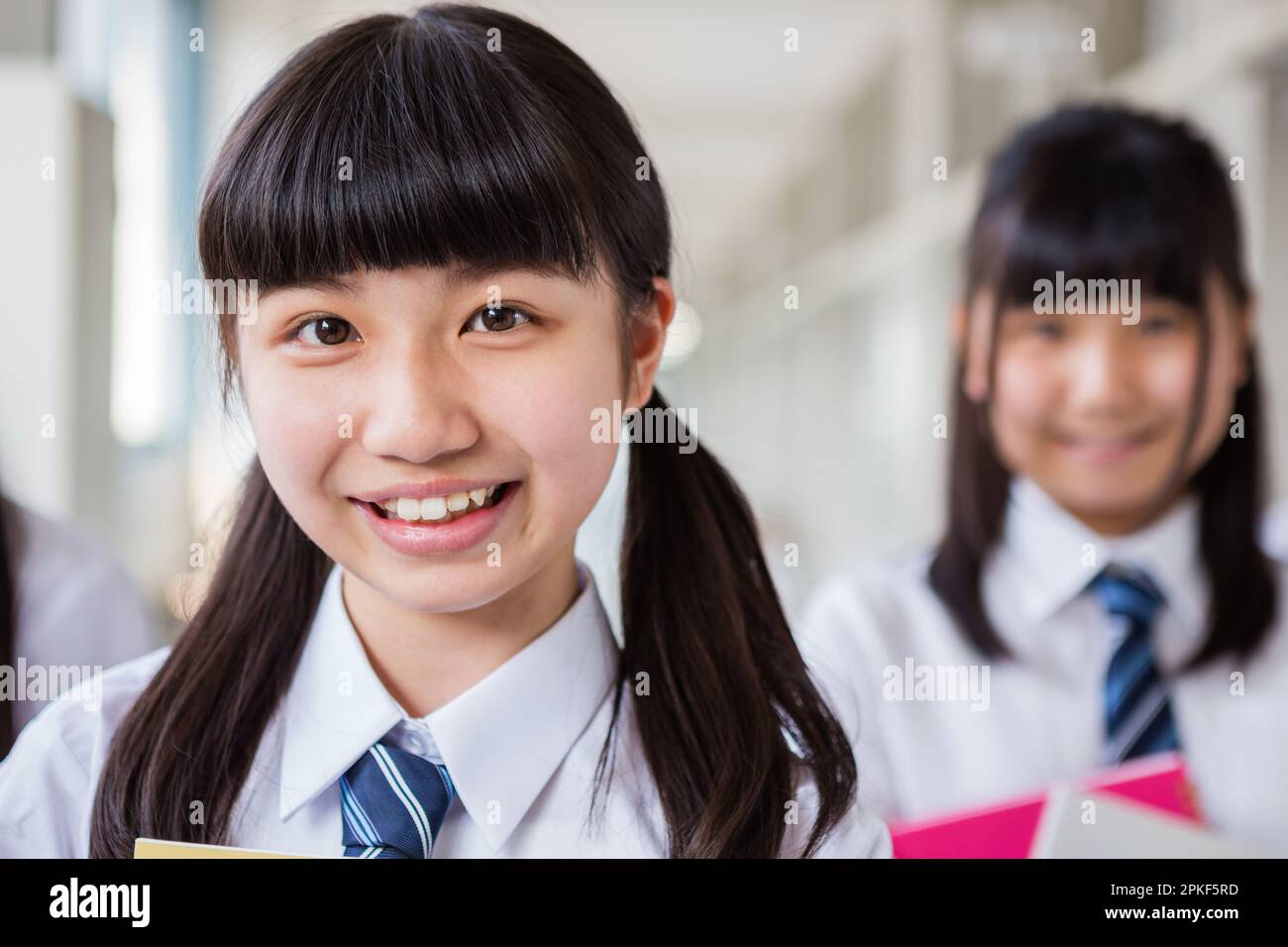 Junior high school girls holding notebooks Stock Photo - Alamy