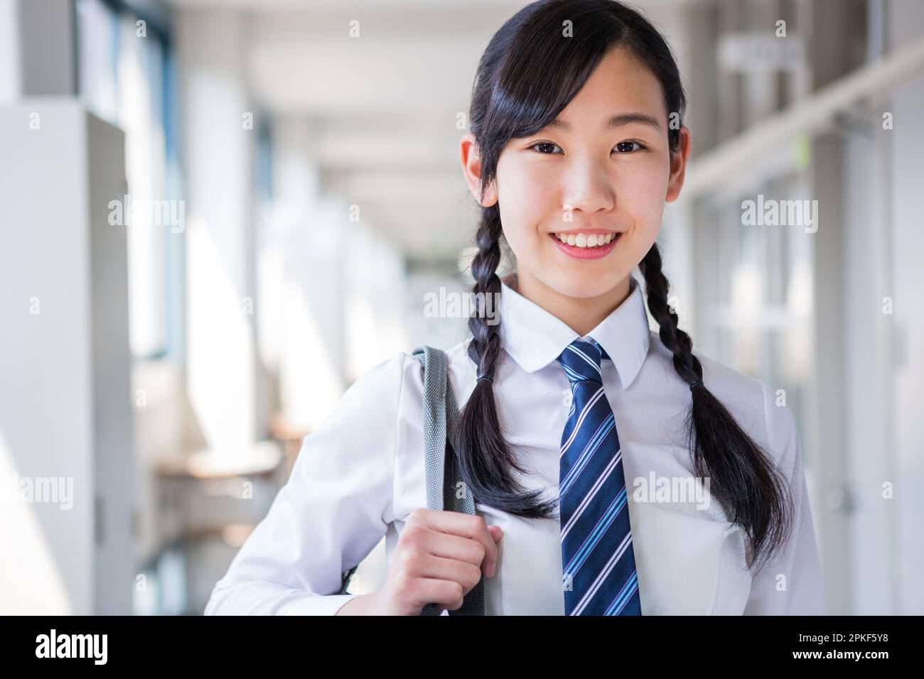 Schoolgirl standing alone in school hi-res stock photography and images - Alamy