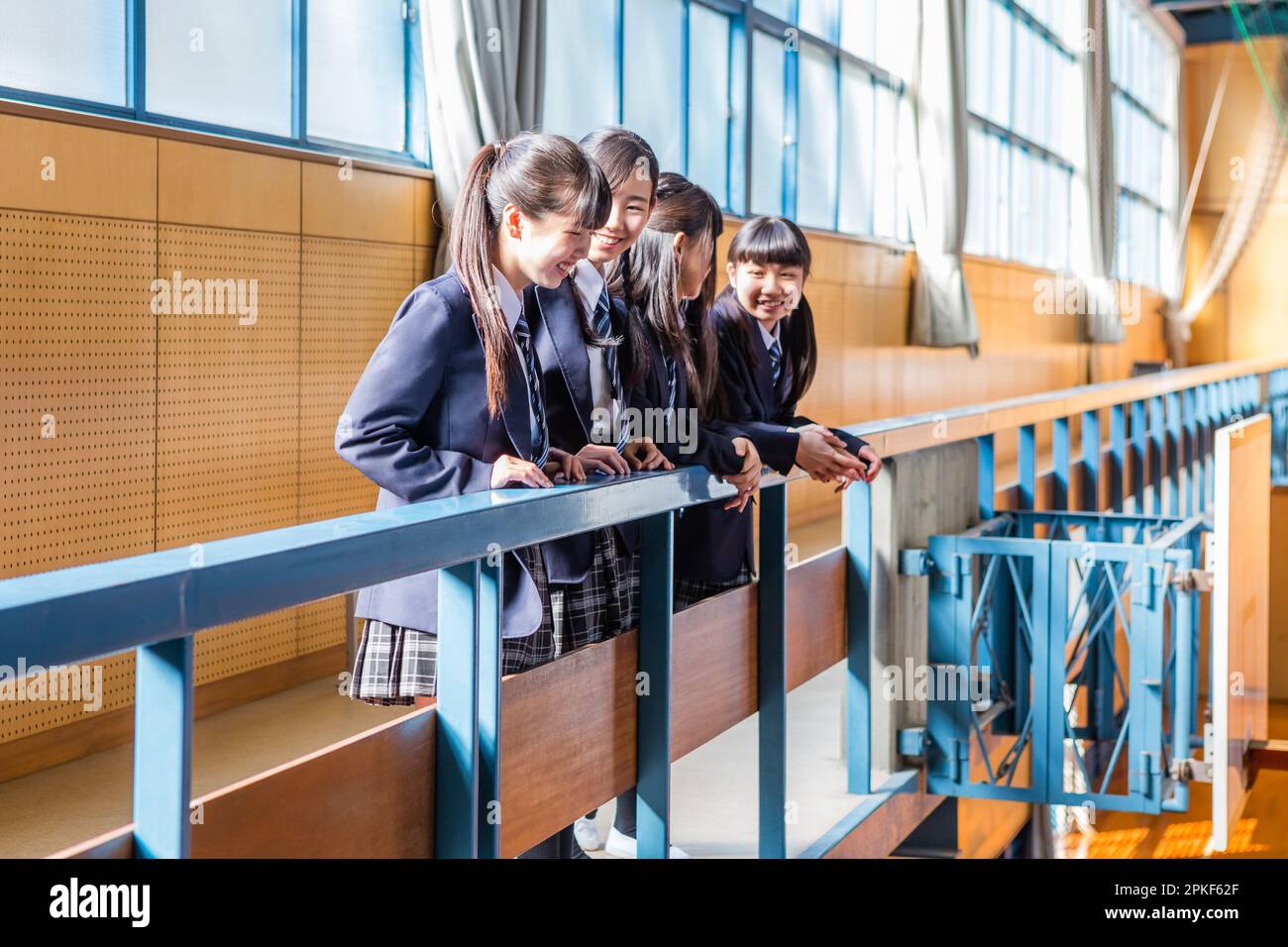 Junior high school girl leaning on the handrail on the second floor of ...
