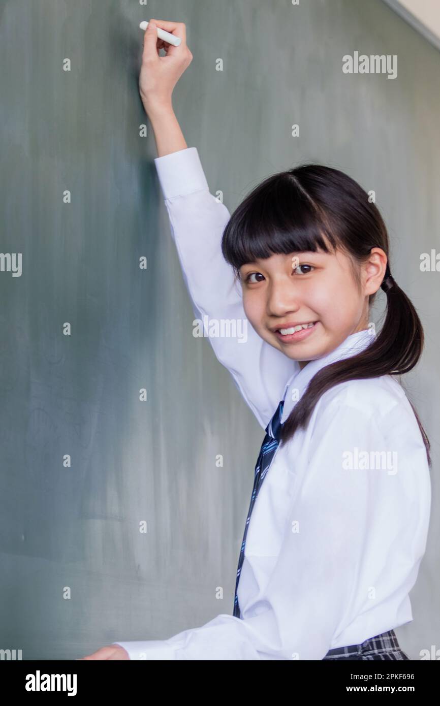 Junior high school girl writing with chalk on the blackboard Stock ...