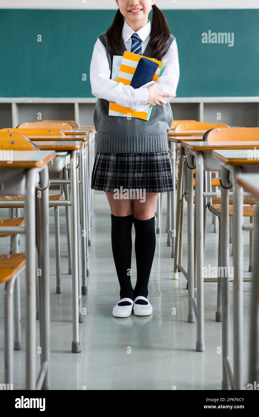 Junior high school girl holding a notebook in a classroom Stock Photo ...