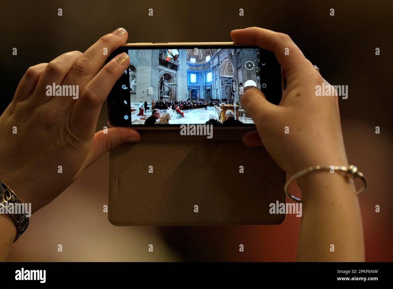 A woman takes a photo to Pope Francis during the Passion Mass on Good ...