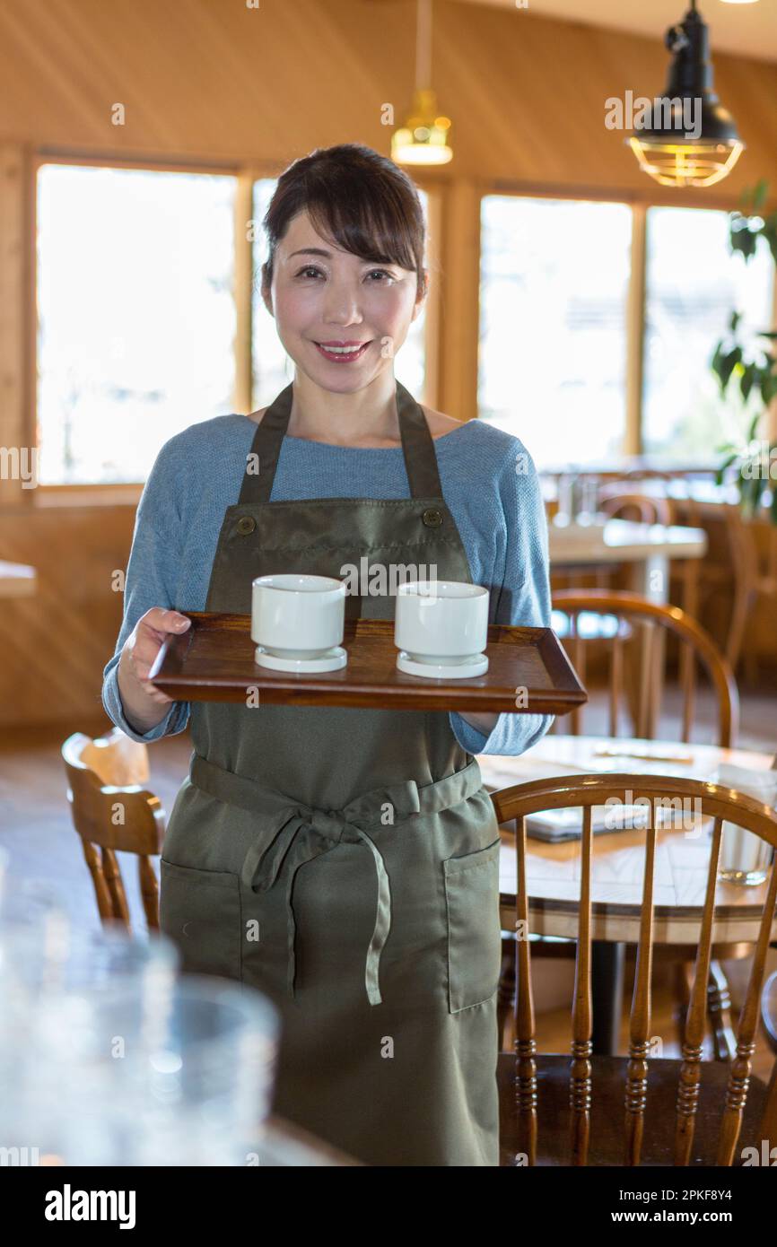 Female waitress standing holding a tray Stock Photo - Alamy