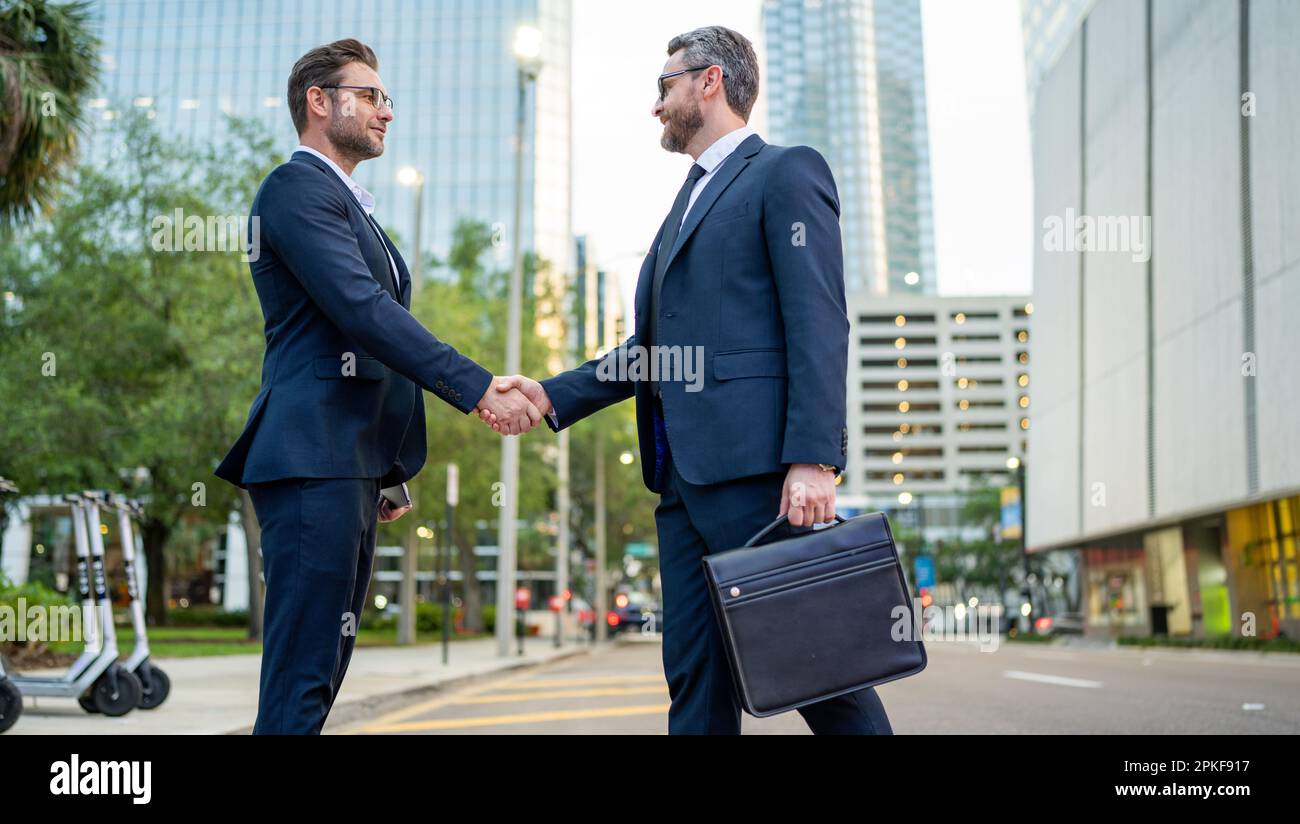 Business man shaking hands. Two businessmen handshake outdoor ...