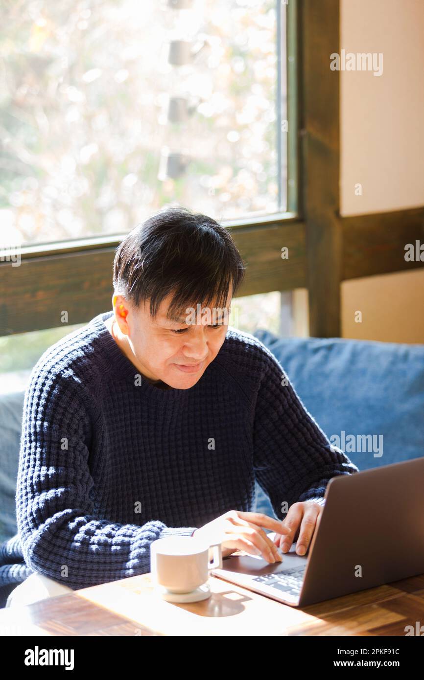 A man working on his computer at a café Stock Photo - Alamy