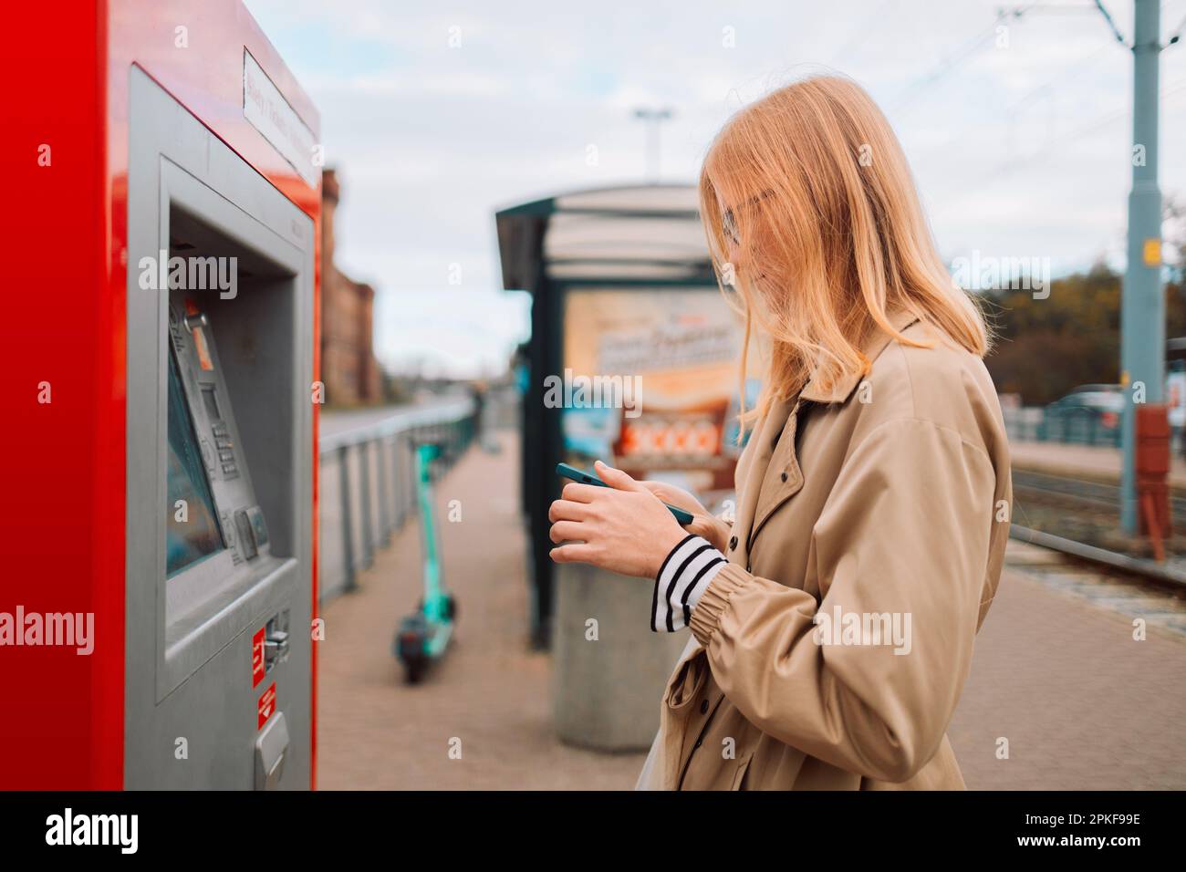 Young pretty blonde woman buying a ticket to the subway train using an ...