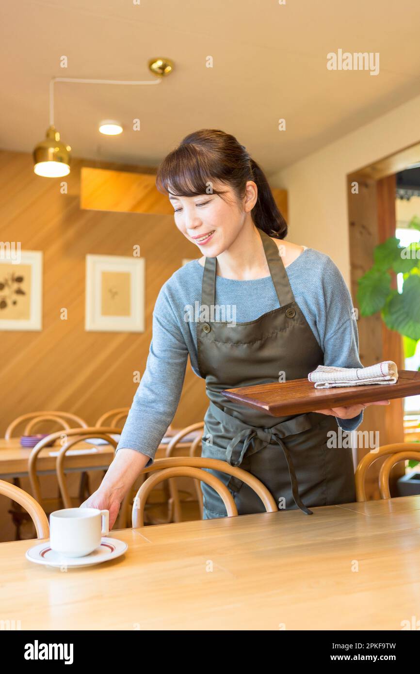 A female waitress clearing a table Stock Photo - Alamy