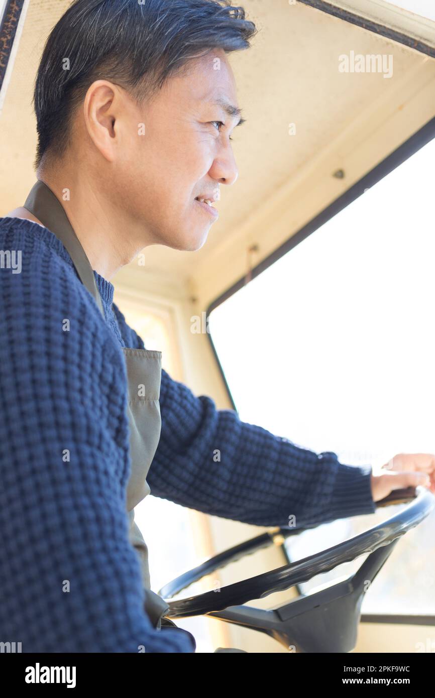 Man driving a tractor Stock Photo - Alamy