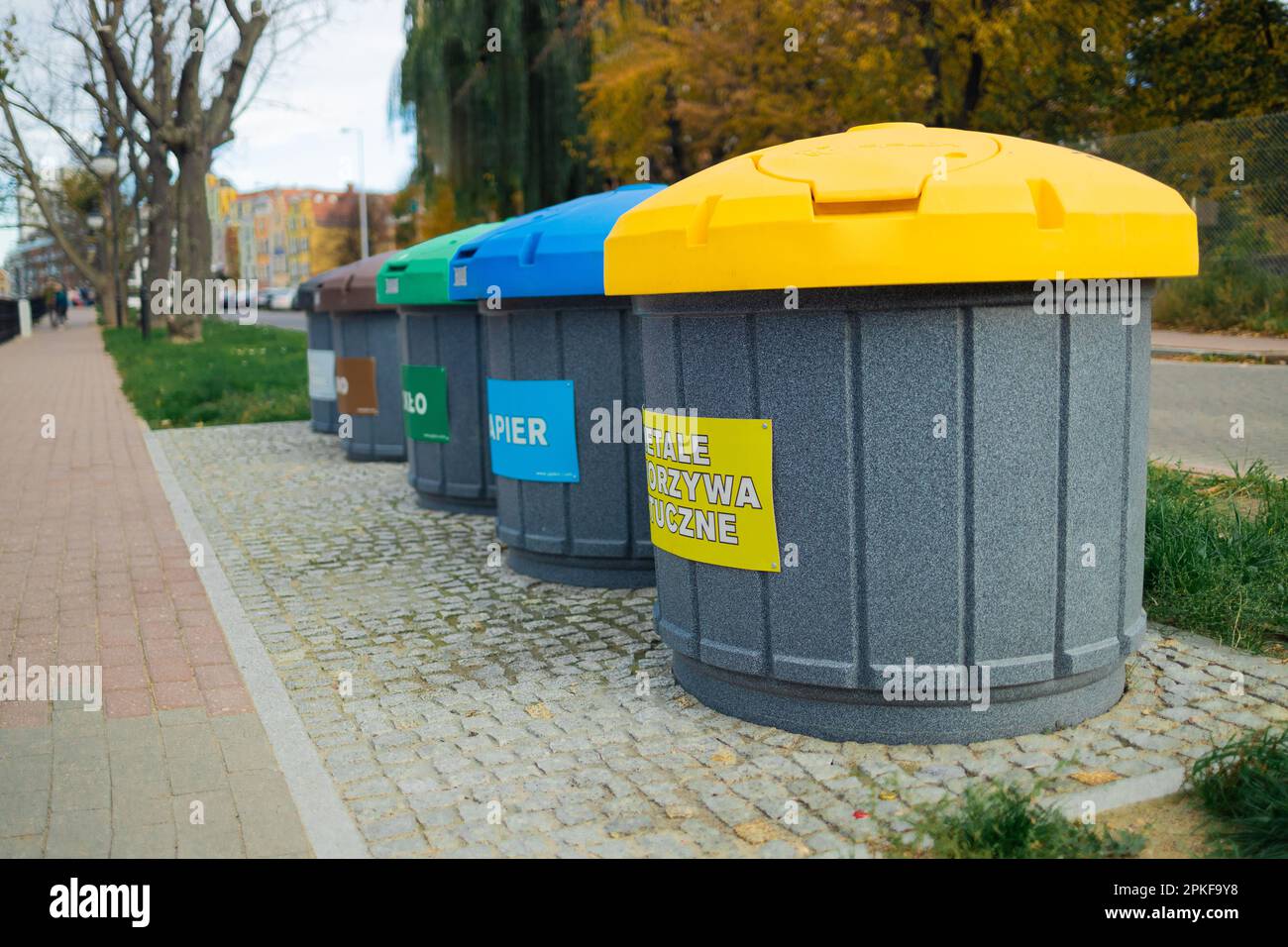 Waste sorting bins, blue, yellow, green and red. There is a sign at the ...