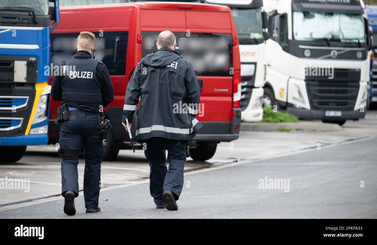 07 April 2023, Hesse, Weiterstadt: Police officers walk towards a red ...