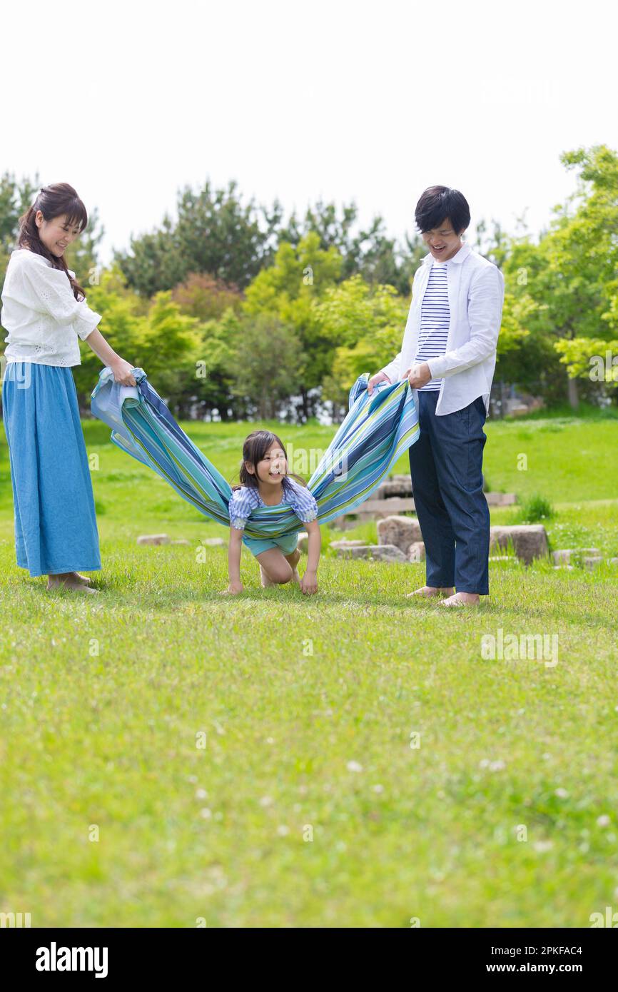 Family spreading out a sheet Stock Photo - Alamy