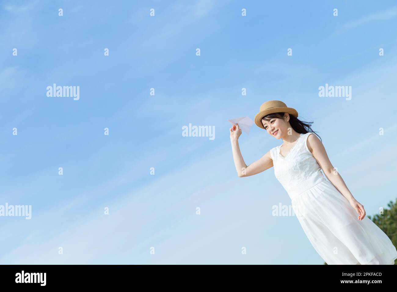 Woman flying paper airplane Stock Photo - Alamy