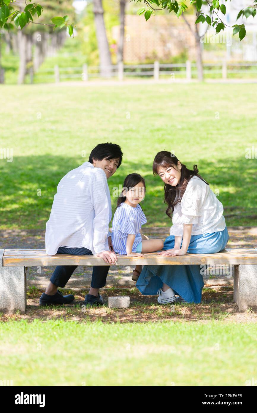 Family sitting on a bench Stock Photo - Alamy