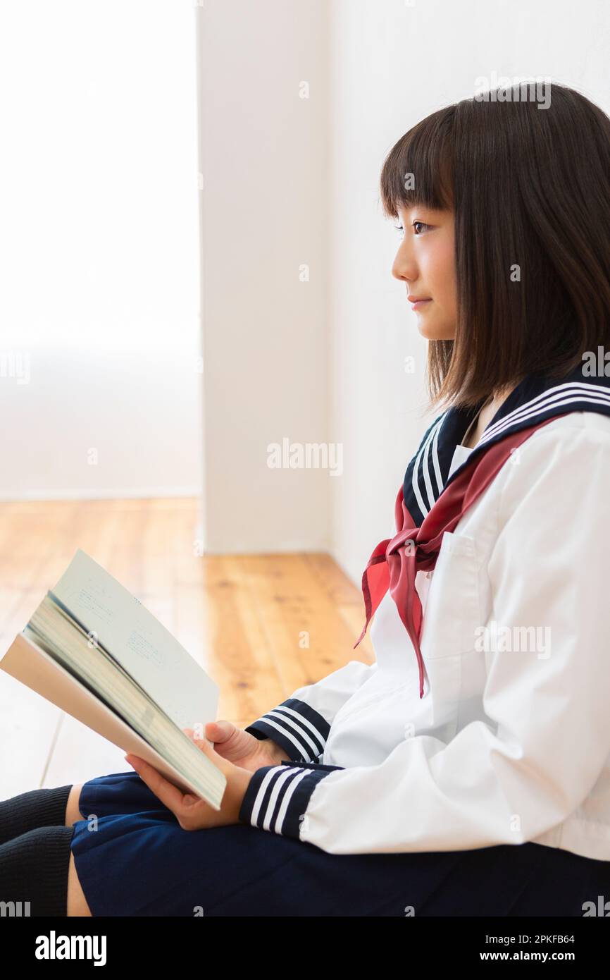 A junior high school girl reading on the floor Stock Photo - Alamy
