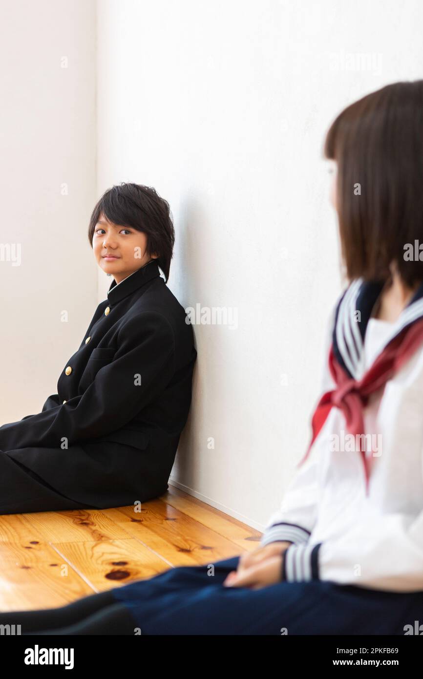Junior high school student sitting on the floor Stock Photo - Alamy