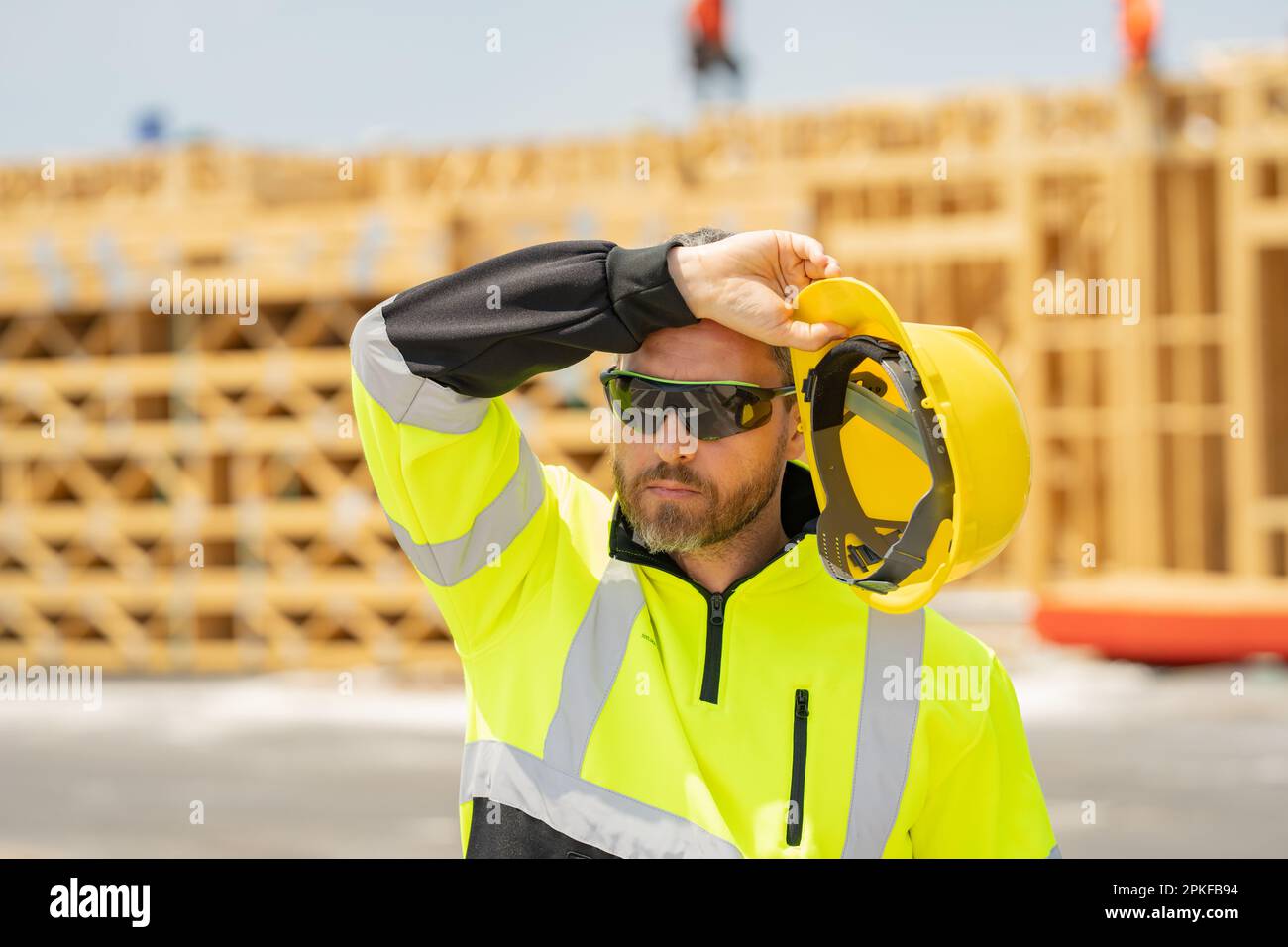 Tired builder, hard work concept. Worker in building uniform on ...