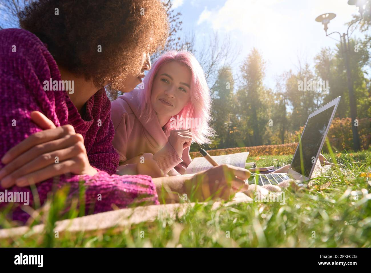 Two female students doing homework in public park Stock Photo - Alamy