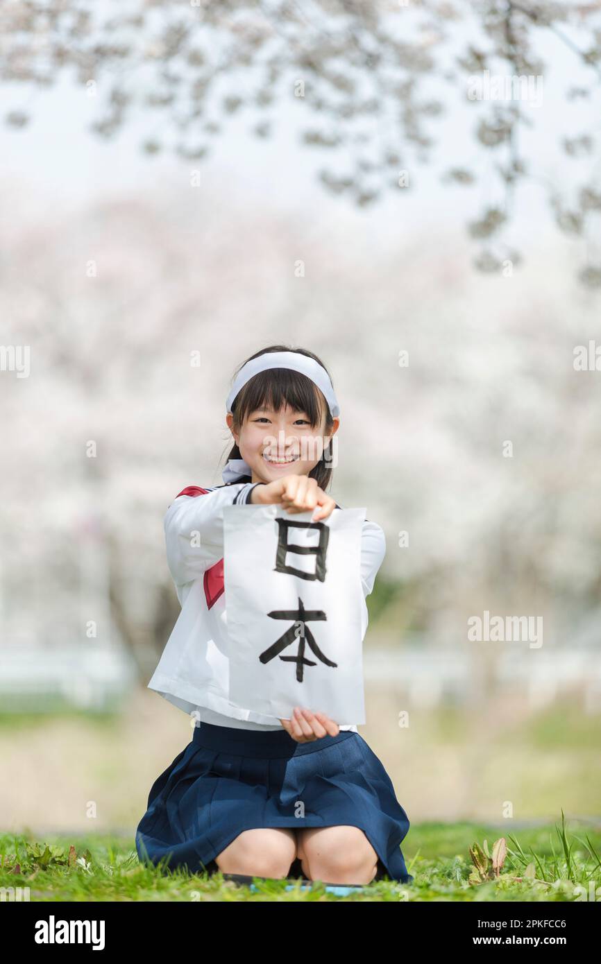 Schoolgirl doing calligraphy under the cherry blossom tree Stock Photo ...